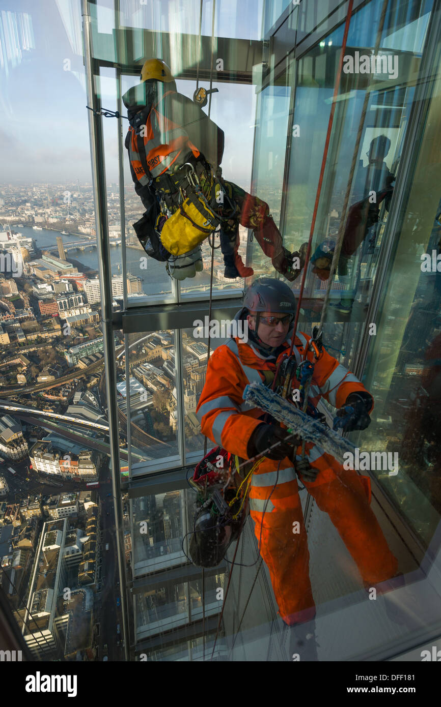 Abseiling window-cleaners cleaning the outside of the glass of the View ...