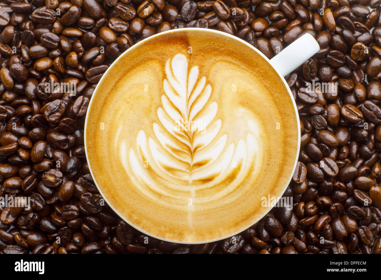 Latte art, coffee in coffee beans background Stock Photo - Alamy