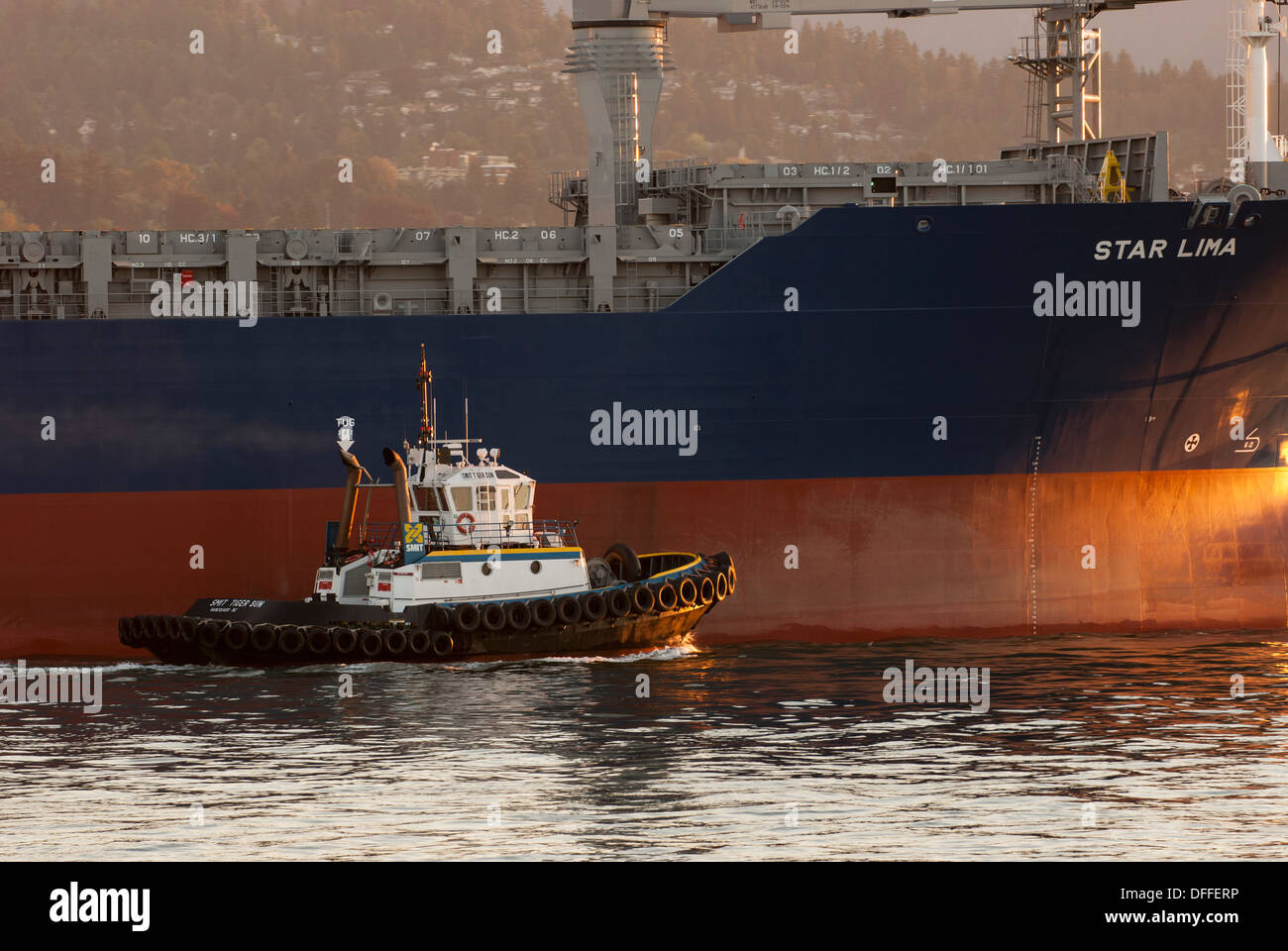 Tug boat guiding a freighter, in Vancouver harbour Stock Photo - Alamy