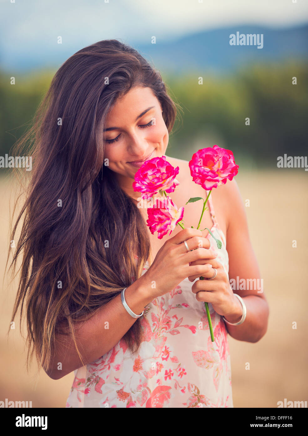 Young woman smelling flowers in nature Stock Photo - Alamy
