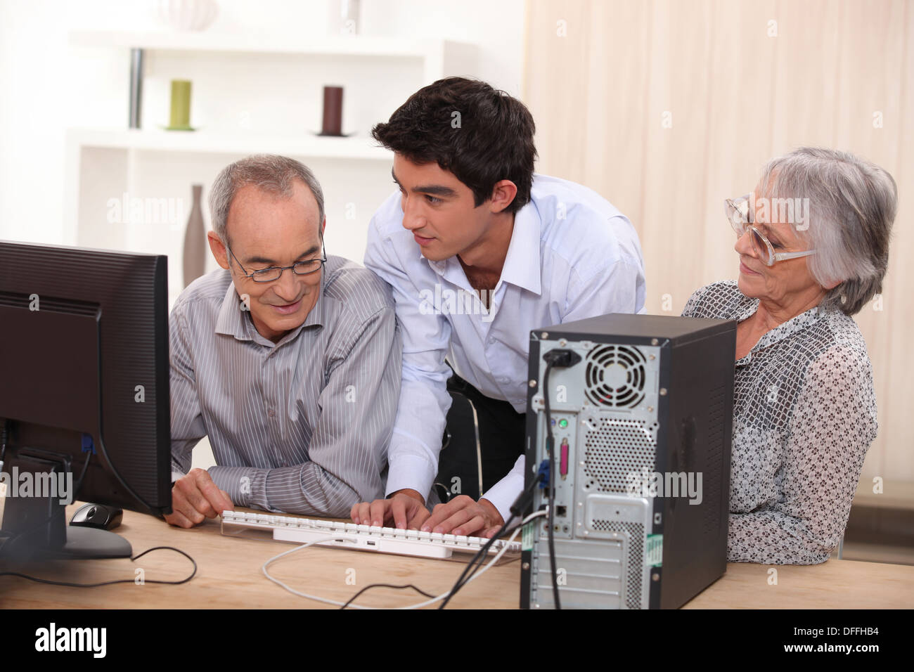 Young helping senior with computer Stock Photo - Alamy