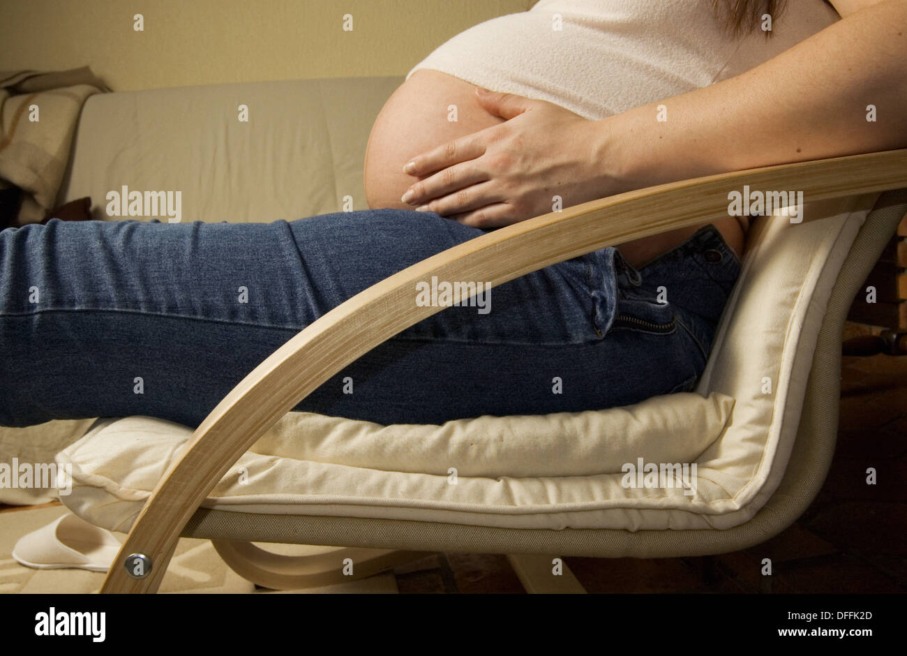 Pregnant woman sitting in chair with protruding stomach Stock Photo - Alamy