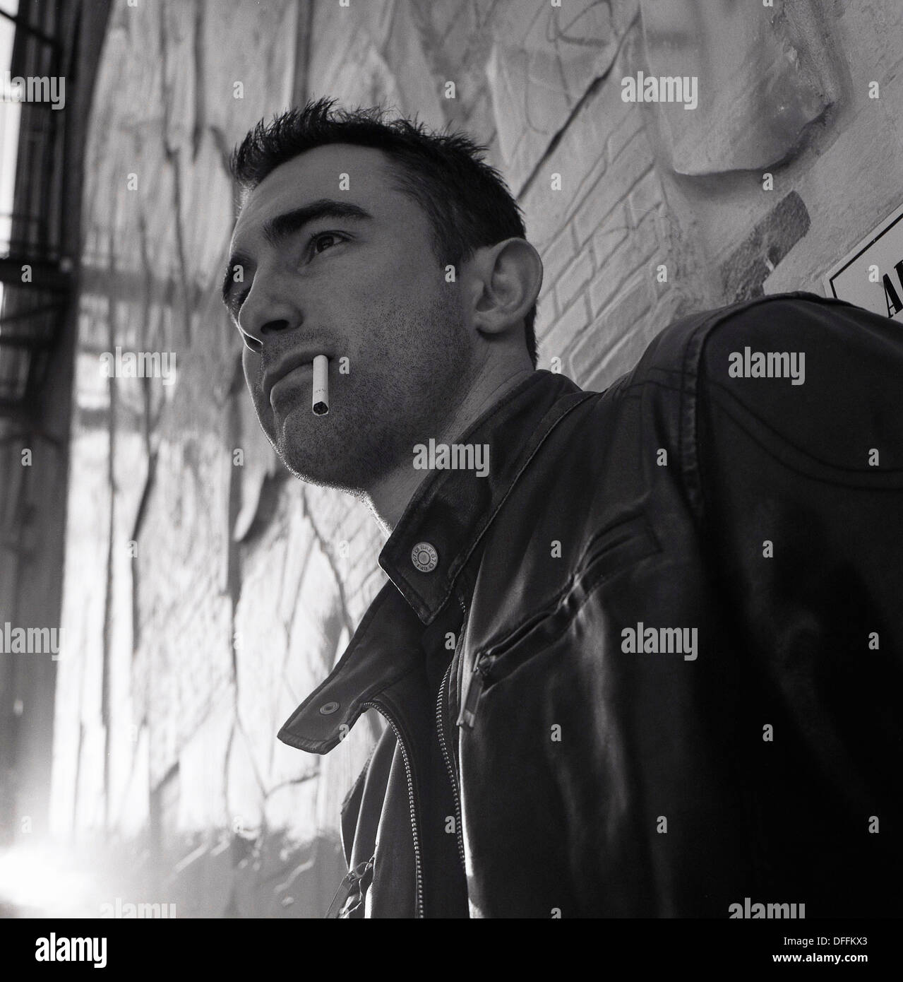Man in alley smoking cigarette hi-res stock photography and images - Alamy