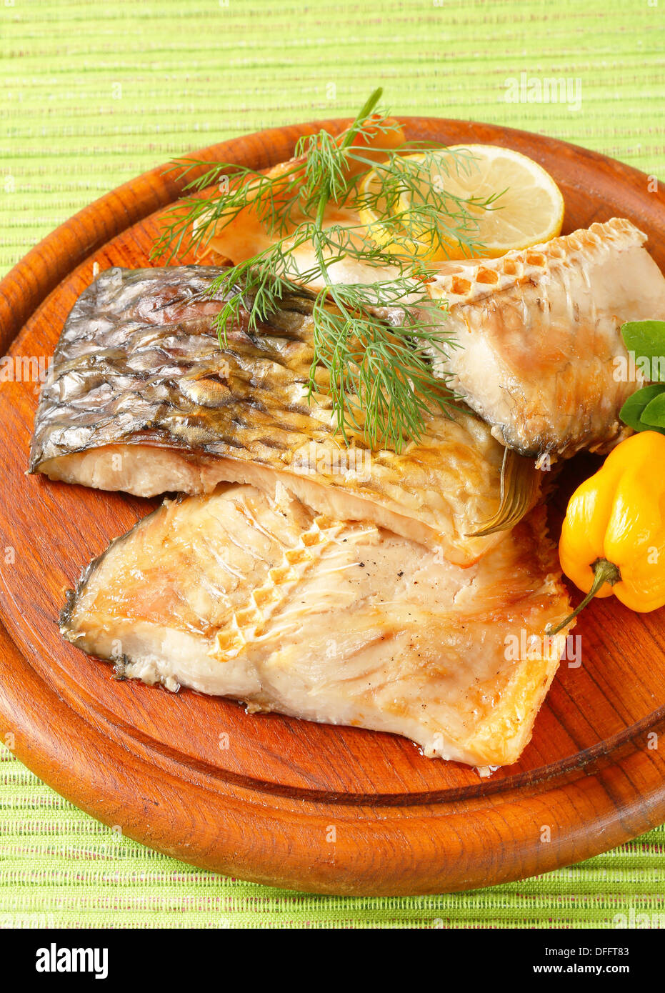 Oven-baked carp fillets on round cutting board Stock Photo - Alamy