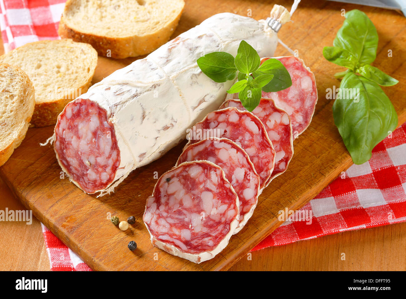 French Saucisson Sec and sliced crispy roll on cutting board Stock ...
