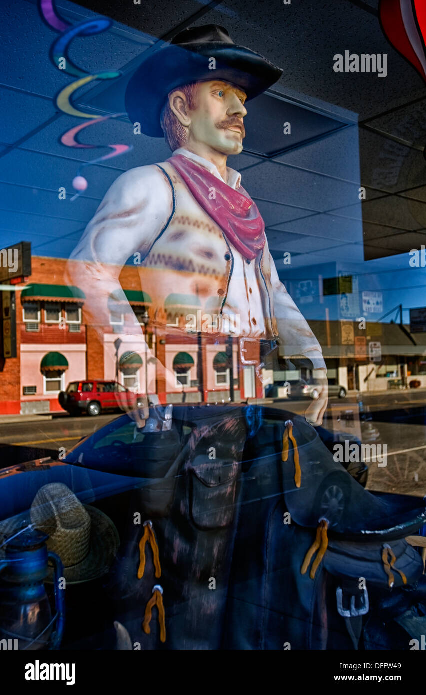 A reflection of a cowboy mannequin in a an antique store window in down ...