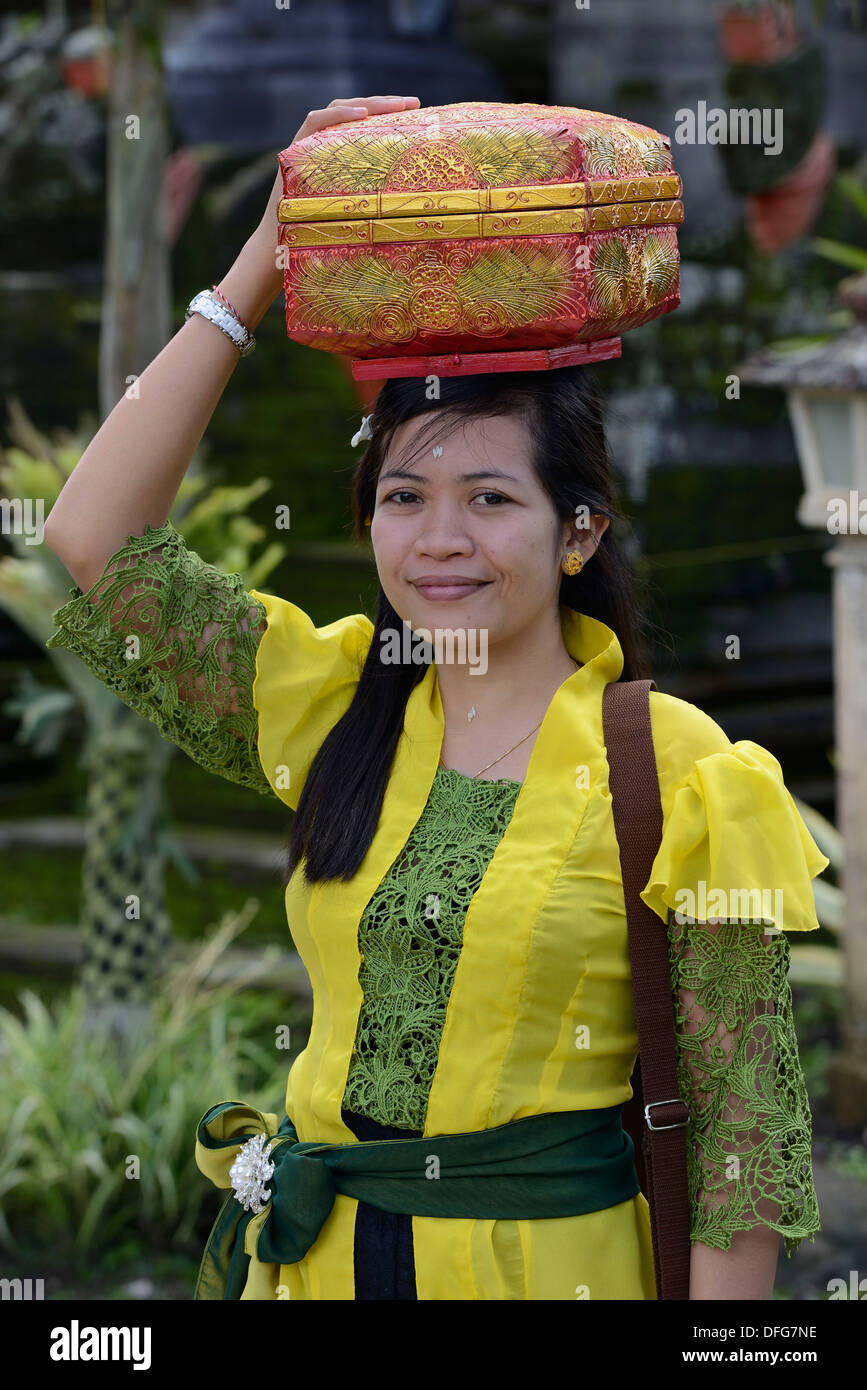 Indonesia, island of Bali, woman carrying offerings at the Pura Ulun ...