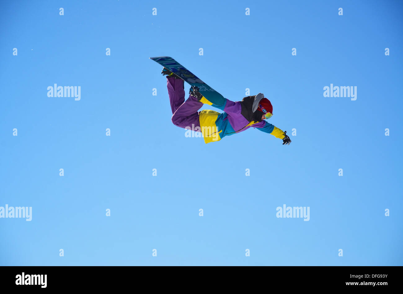A freestyle snowboarder performs an aerial trick as he launches from a ...
