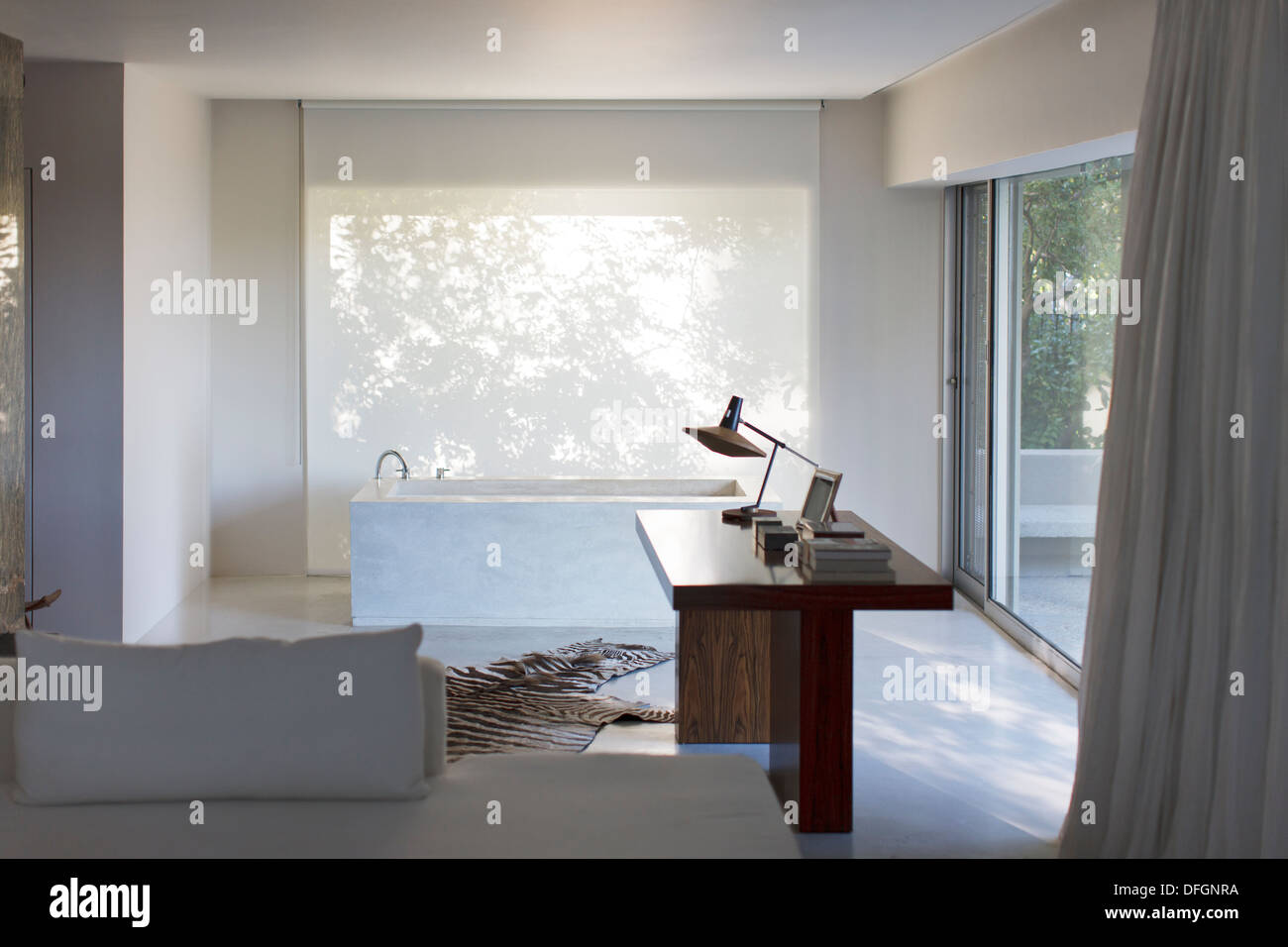 Desk and bathtub in modern house Stock Photo - Alamy