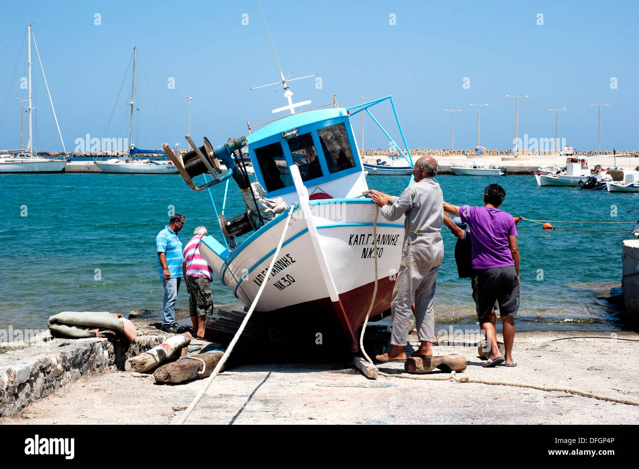 Fishermen work to launch a fishing boat to the sea in Kasos Island ...
