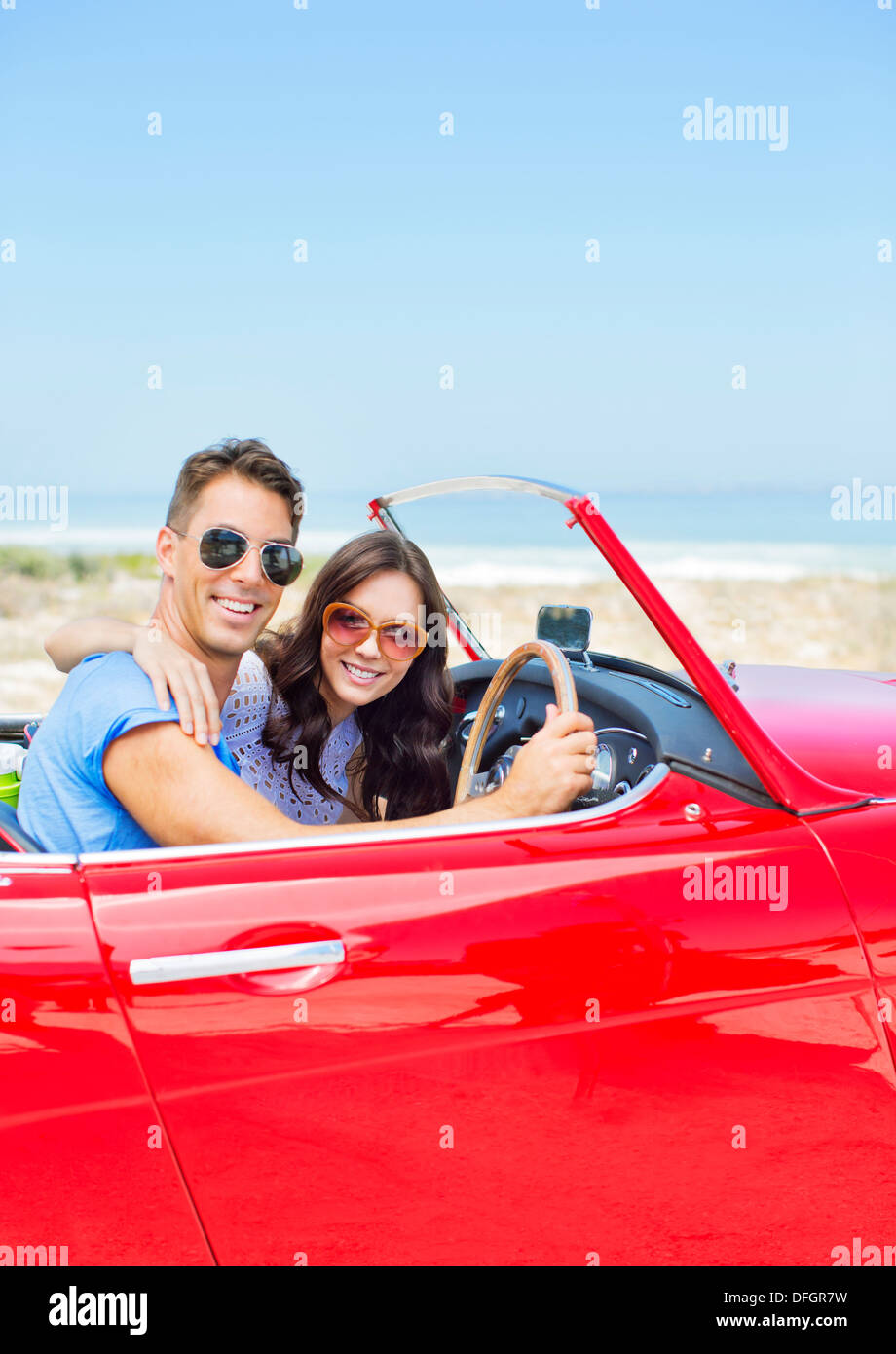 Couple driving convertible at beach Stock Photo - Alamy