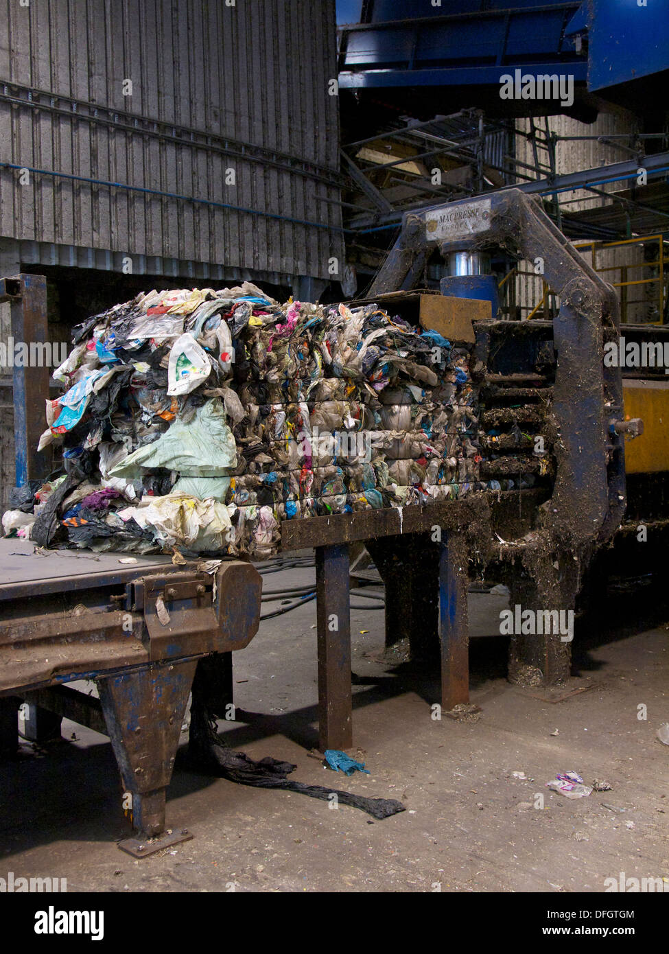 Bale of waste plastic on hydraulic press in recycling plant. The ...