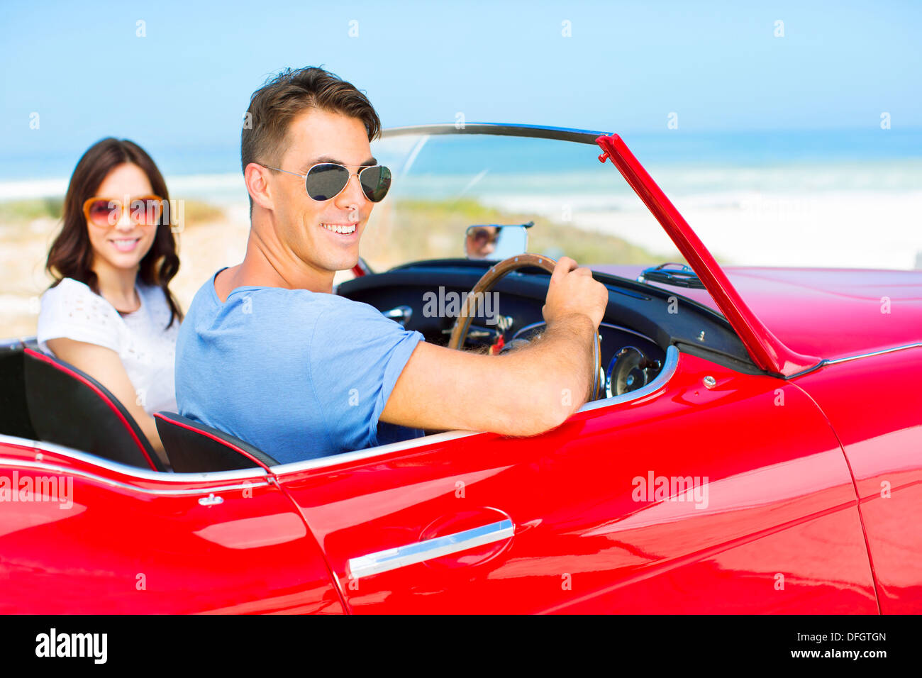 Couple driving convertible on beach Stock Photo - Alamy