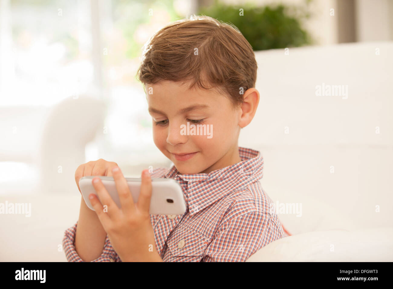 Kid boy child using phone sofa hi-res stock photography and images - Alamy