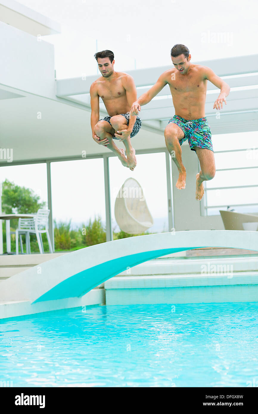 Men jumping into swimming pool Stock Photo - Alamy