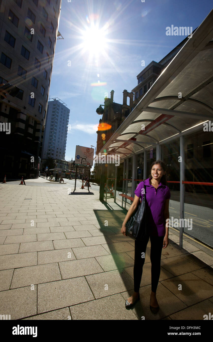 Asian female student at bus stop Stock Photo - Alamy
