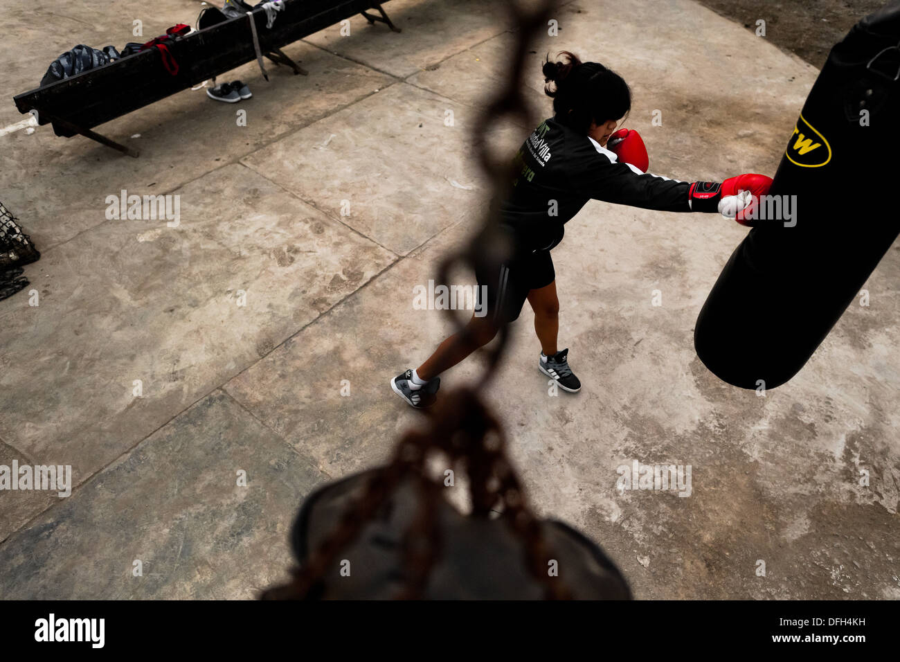 A young Peruvian girl practices with a punching bag at the Boxeo VMT ...