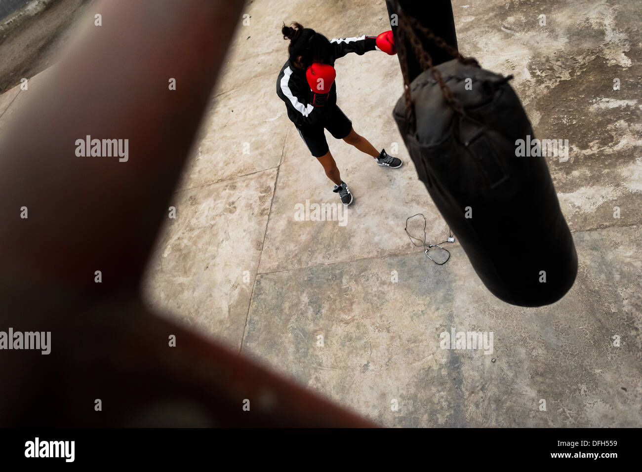 A young Peruvian girl practices with a punching bag at the Boxeo VMT ...