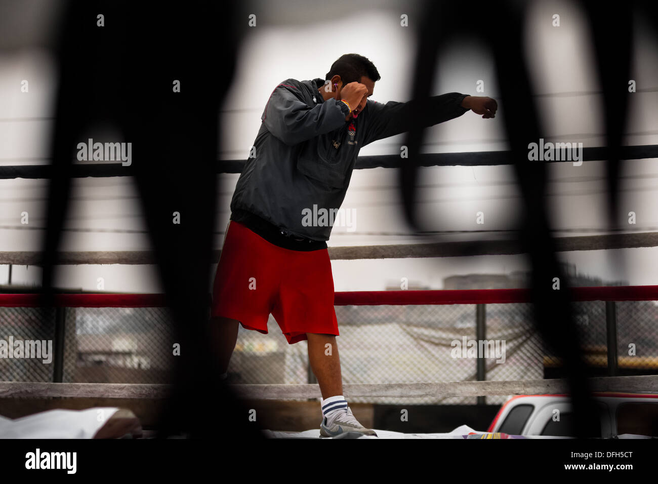 A Peruvian youth practices shadowboxing in the ring at the Boxeo VMT ...