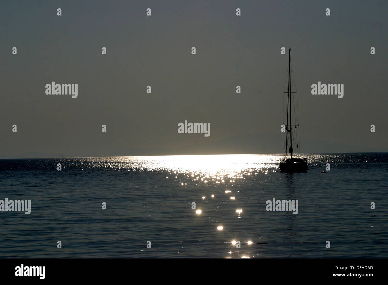 Boat sailing away at sundown Stock Photo - Alamy
