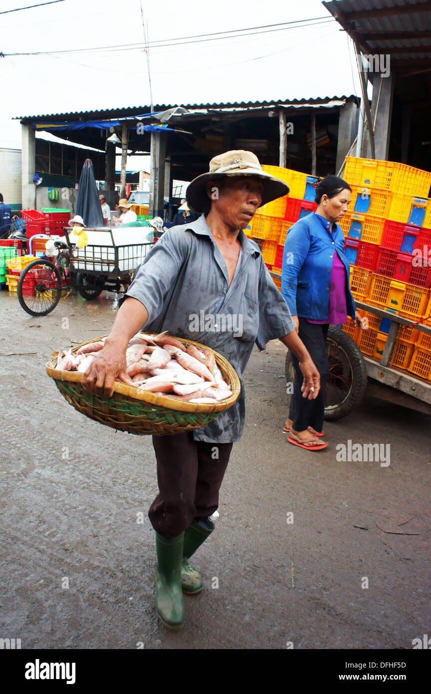 The man with tired face carry fish basket into fishing market in ...
