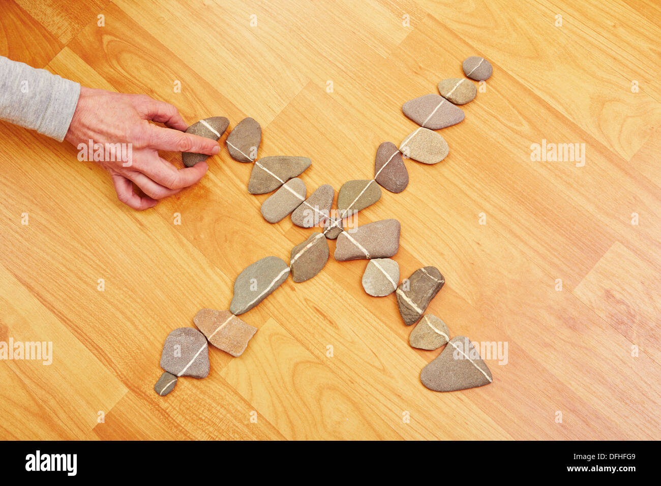 Hand putting a stone to many stones that are showing a cross Stock ...