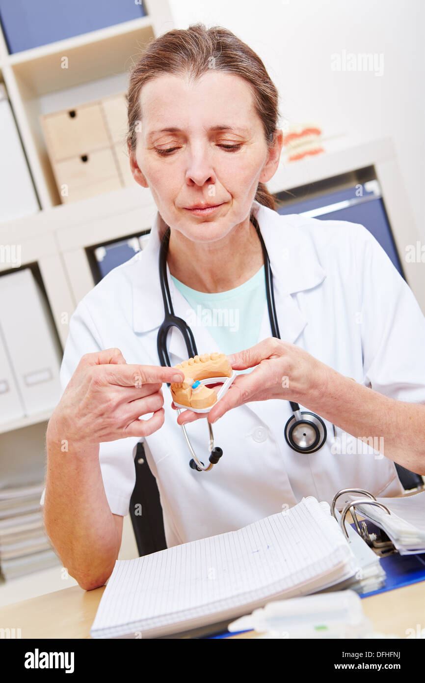 Dental technician in her office showing denture model Stock Photo - Alamy