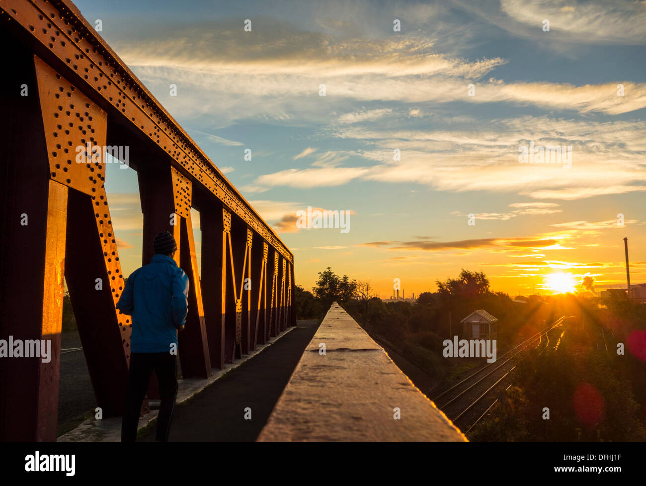 Rear view ofman running over bridge at sunrise. UK Stock Photo - Alamy