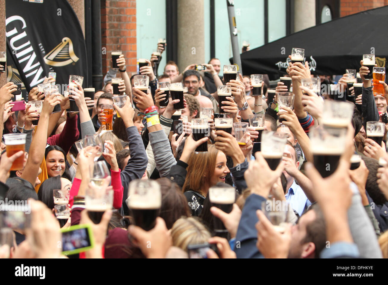 Image People In A Crowd Holding Pints Of Guinness In The Air During The