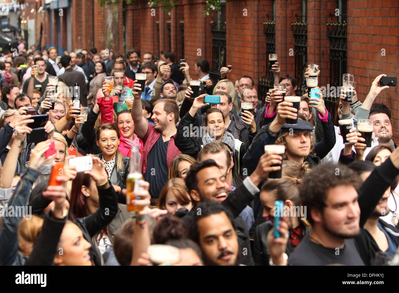 Image people in a crowd holding pints of Guinness in the air during the ...
