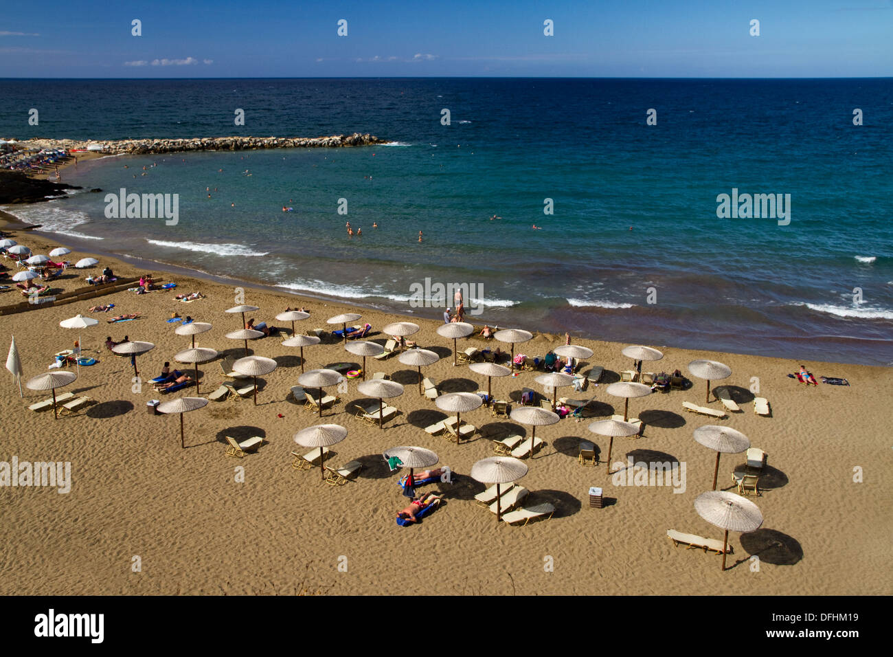 Beach umbrellas and Sunbathers at Panormos, Crete, Greece Stock Photo ...