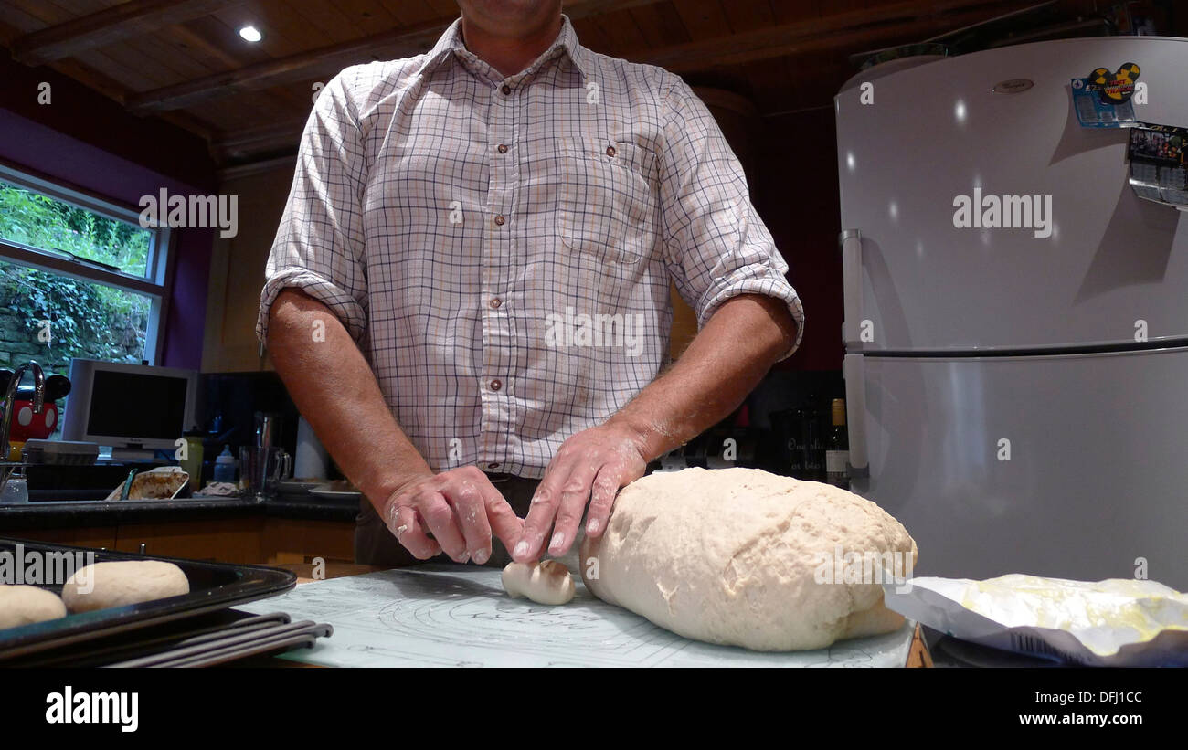 Mid section of man shaping bread dough rolls at kitchen counter Stock ...