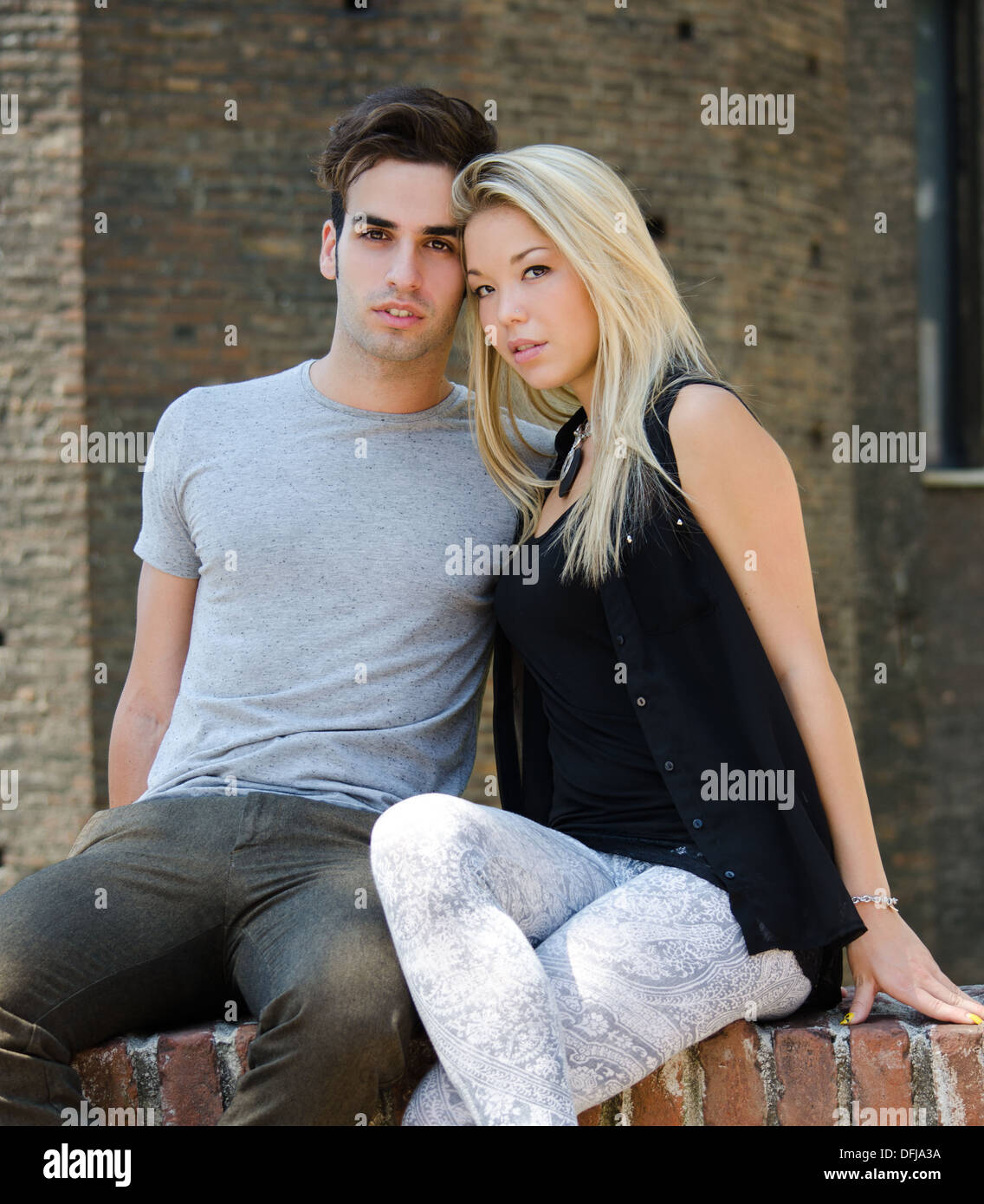 Attractive couple sitting and leaning towards each other looking in ...