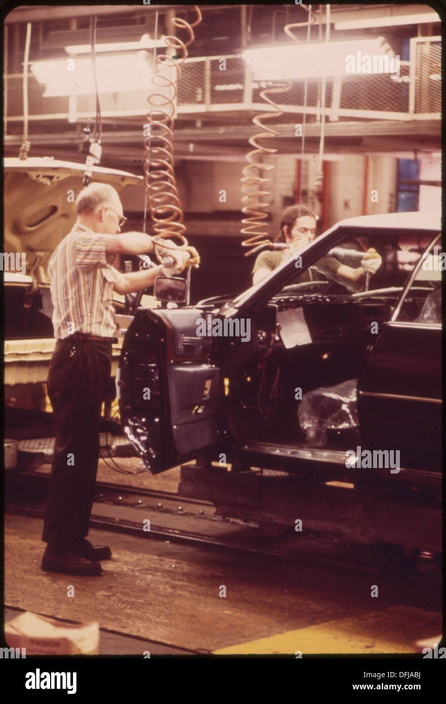 Workers install body wiring on the Cadillac assembly line, a critical ...