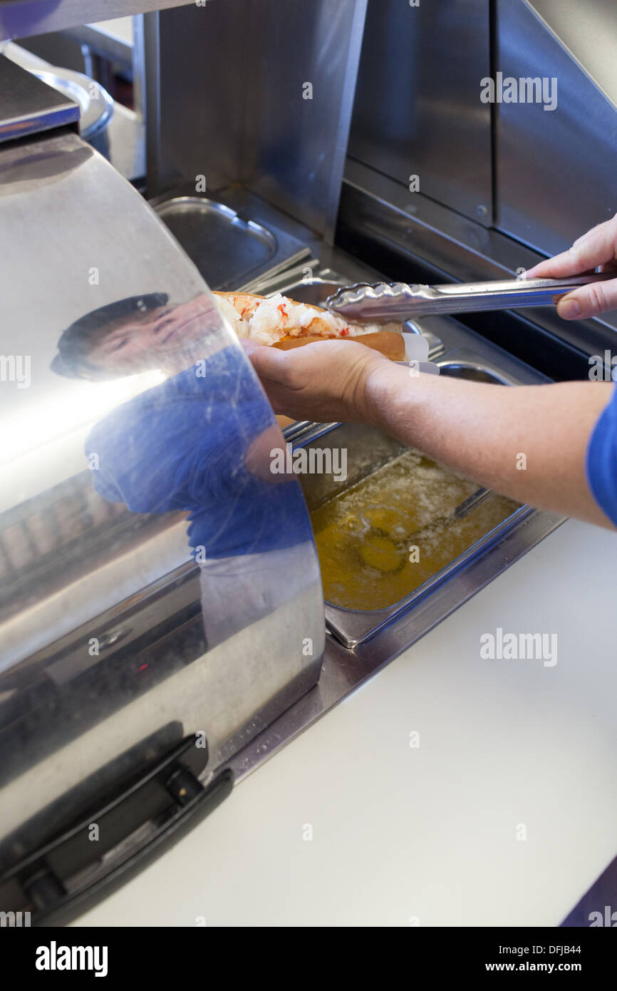 Susan Tierney prepares a hot buttered lobster roll in the kitchen of ...