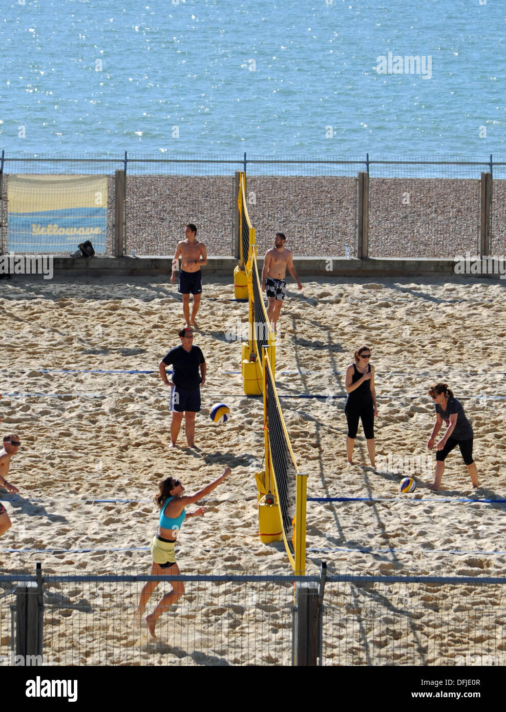 People make the most of the good weather as they play beach volleyball ...