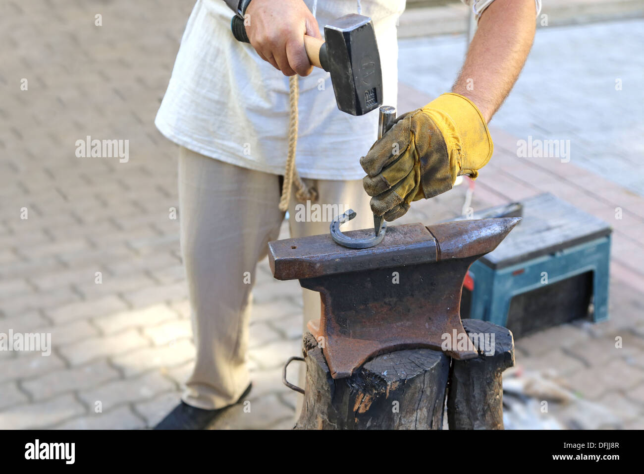 Blacksmith punches holes in the horseshoe Stock Photo - Alamy