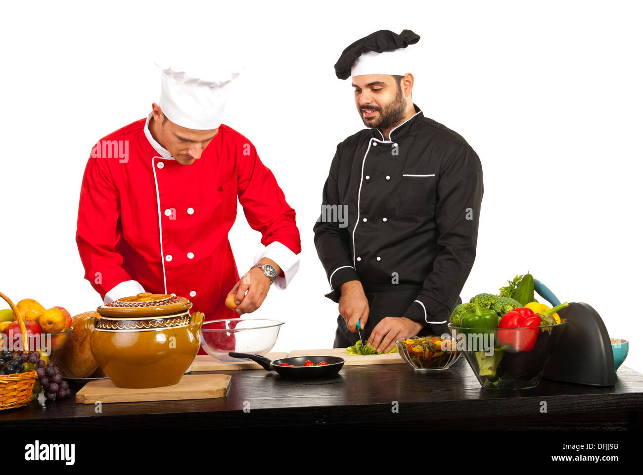 Two chefs preparing food in kitchen against white background Stock ...