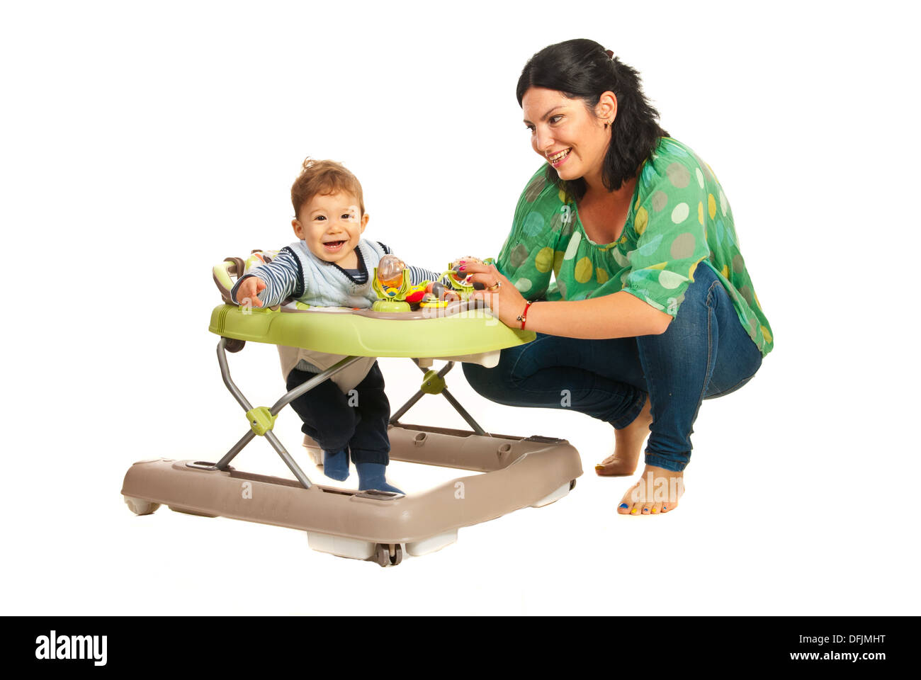 Mother talking with her baby son in walker against white background ...