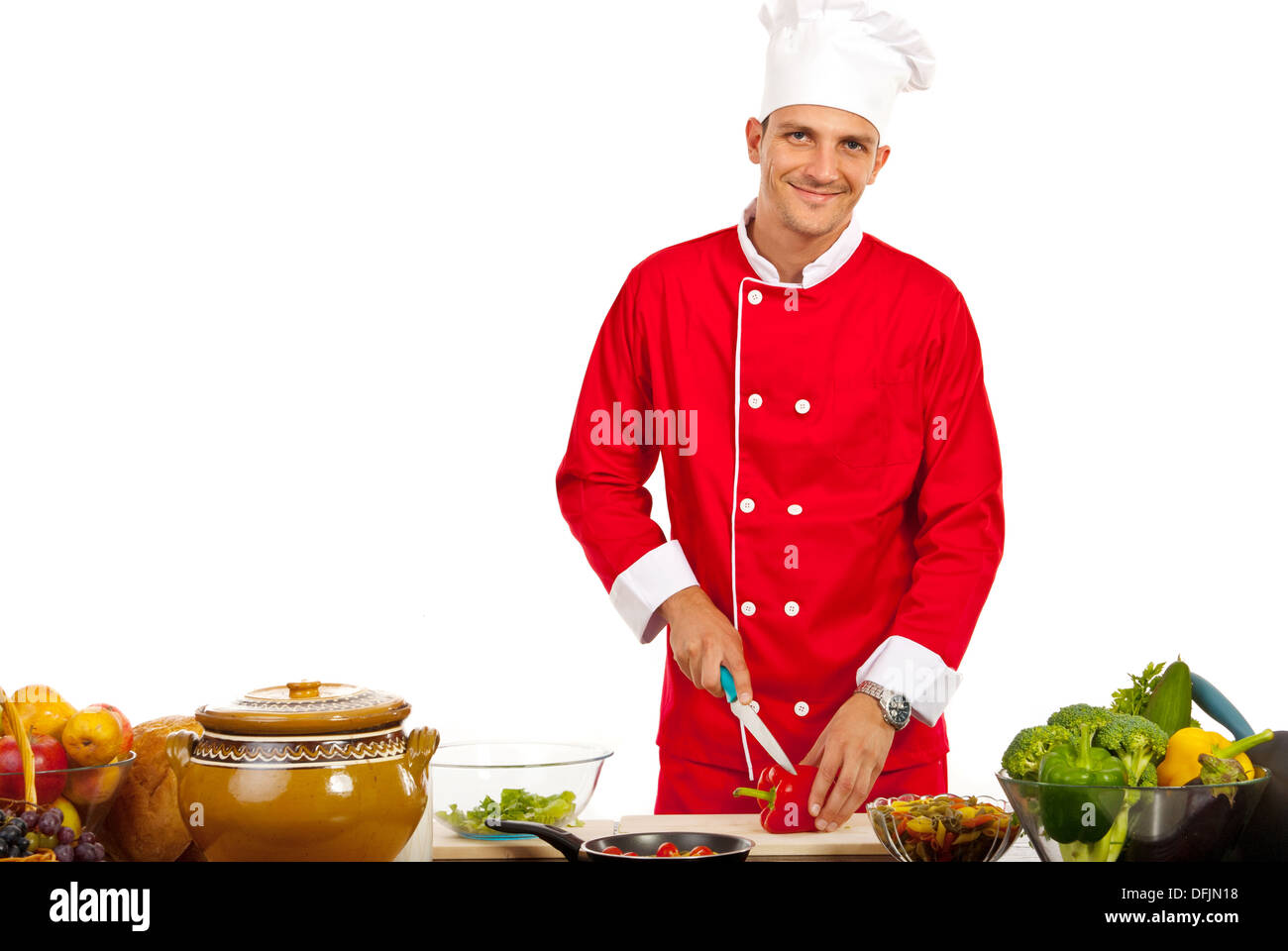Happy chef in red uniform cutting bell pepper in kitchen Stock Photo ...