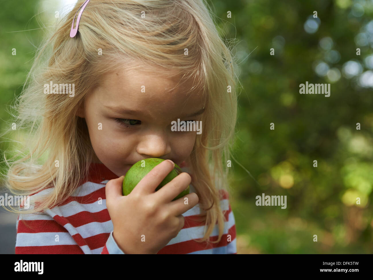 Portrait of Child blond girl eating pear summer outside Stock Photo - Alamy