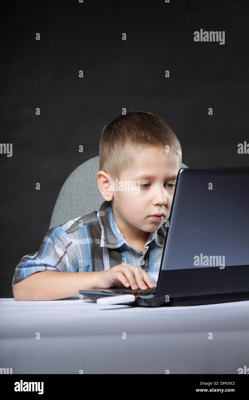 Computer addiction child boy with laptop notebook black background ...