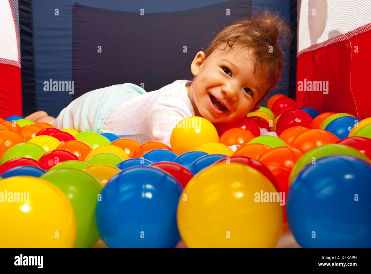 Happy baby boy lying on colorful balls in playpen Stock Photo - Alamy