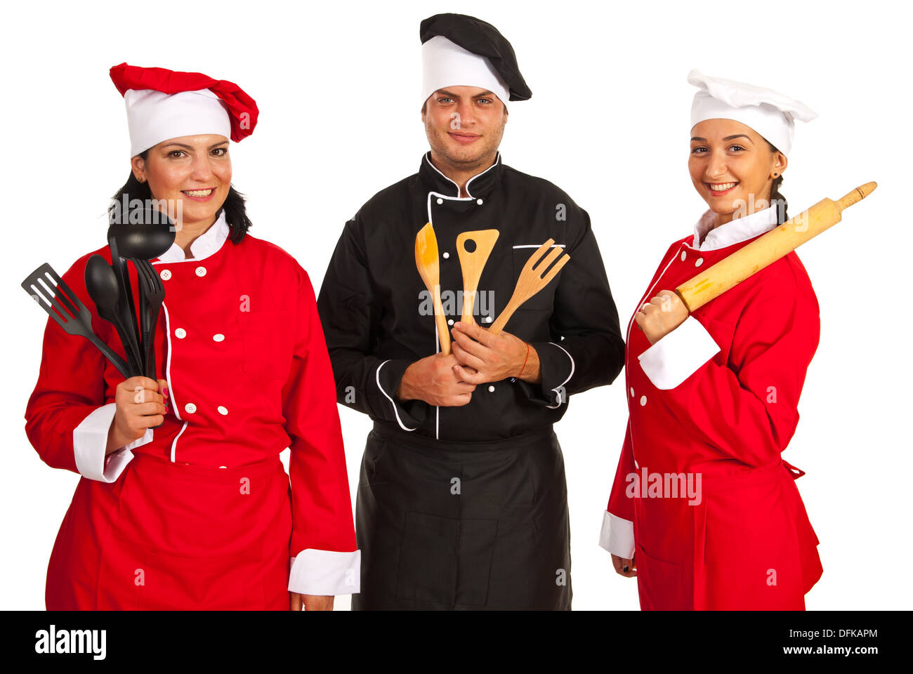 Happy team of three chefs holding kitchen utensils isolated on white ...