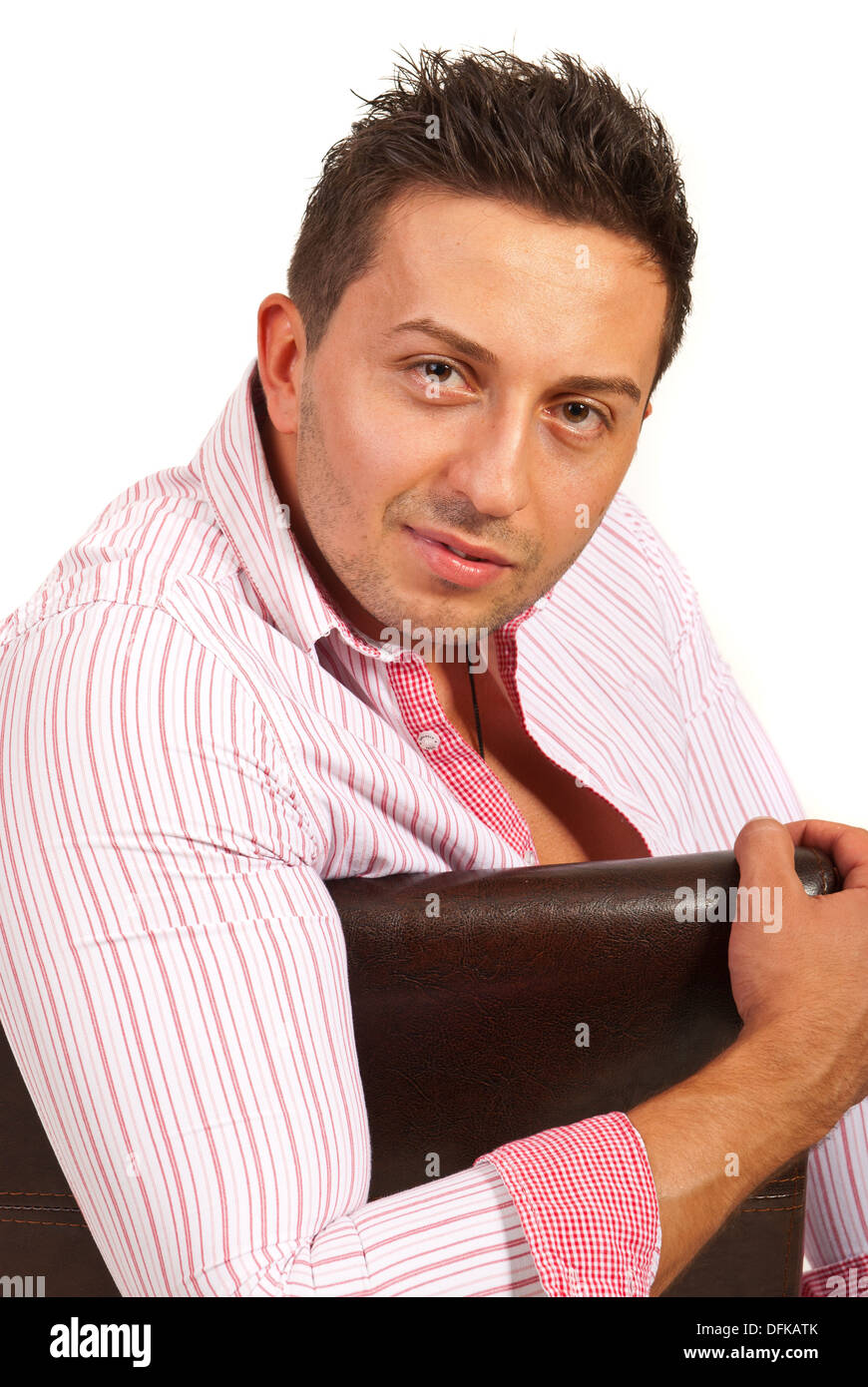 Handsome male sitting on chair and smiling isolated on white background ...