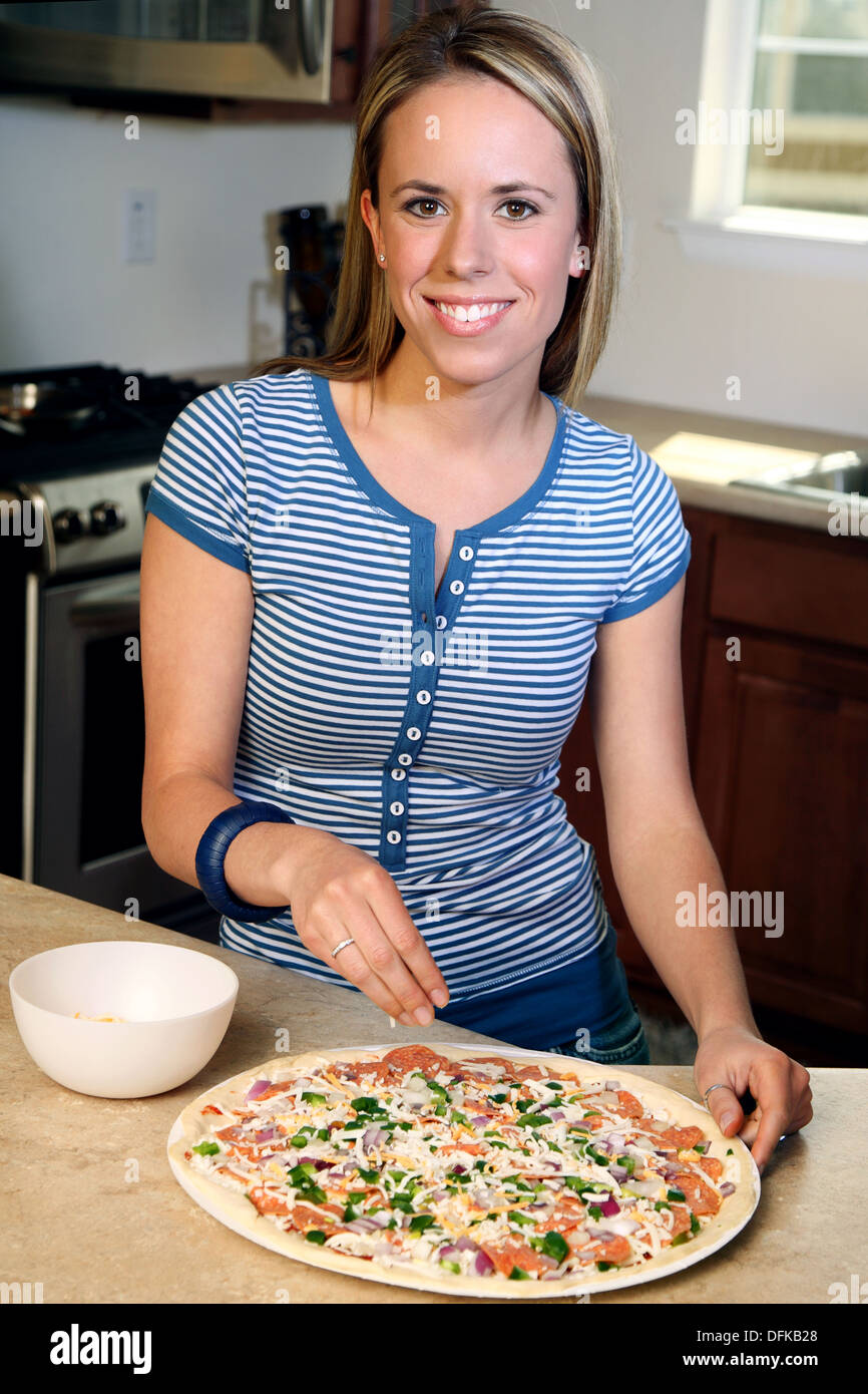 Young attractive housewife making a pizza Stock Photo - Alamy