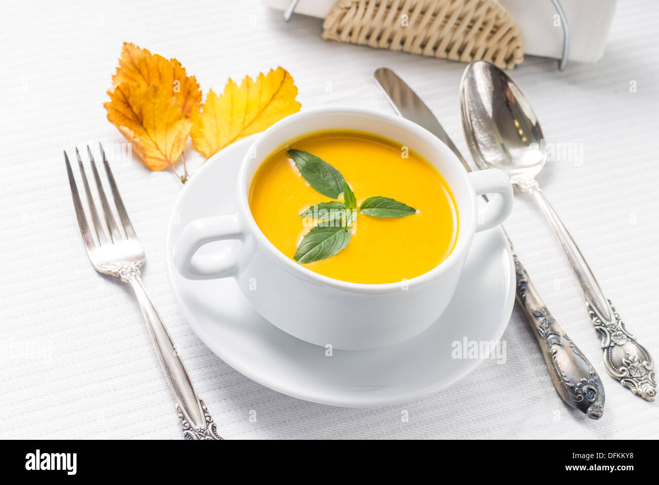 Pumpkin soup with basil on served table Stock Photo - Alamy