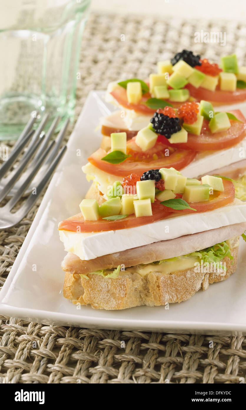 Canapes of turkey, brie, tomatoe and avocado Stock Photo - Alamy