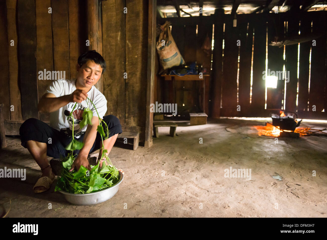 Minority group Black Hmong man trim the vegetable for lunch, Sa Pa ...