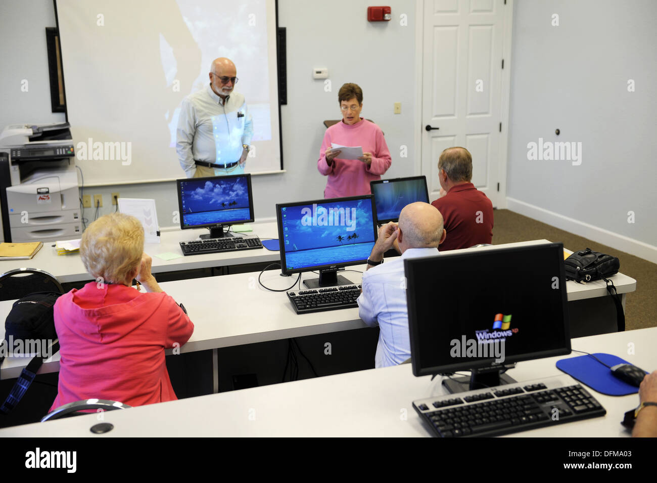 Adult Men and Women using technology in computer learning center Stock ...